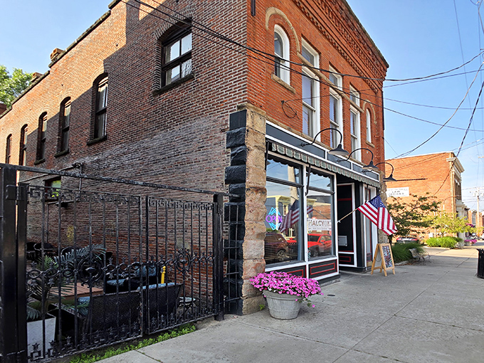 The historic brick façade of Harbor Halcyon welcomes visitors with classic charm and an American flag, promising culinary adventures in Ashtabula Harbor.