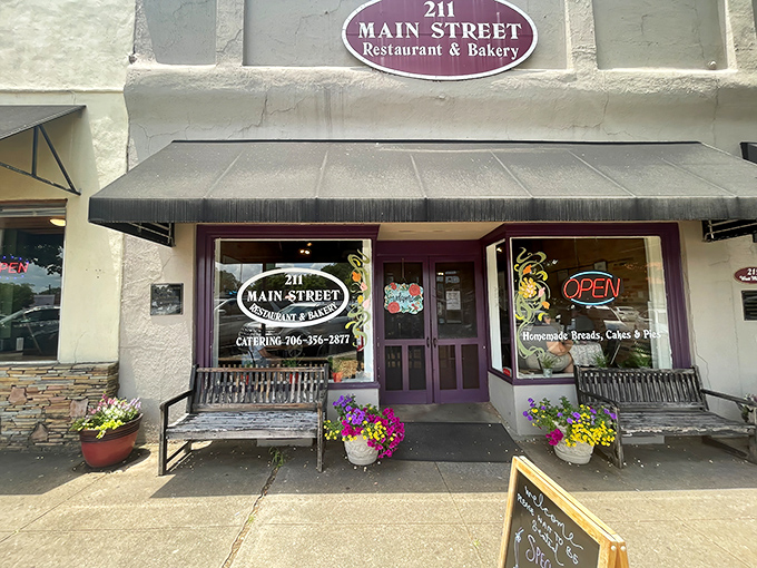 The welcoming storefront of 211 Main Street beckons with colorful flower pots and metal benches. Small-town charm doesn't get more inviting than this purple-trimmed slice of heaven.