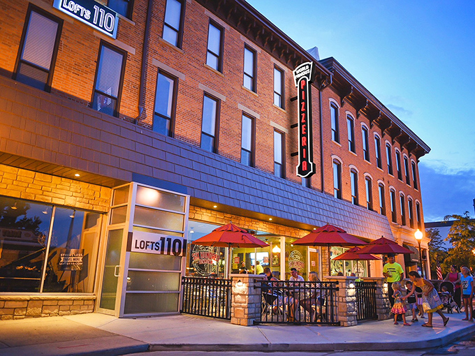 The historic brick façade of Six Hundred Downtown welcomes pizza pilgrims with its cheerful red umbrellas and inviting patio seating.