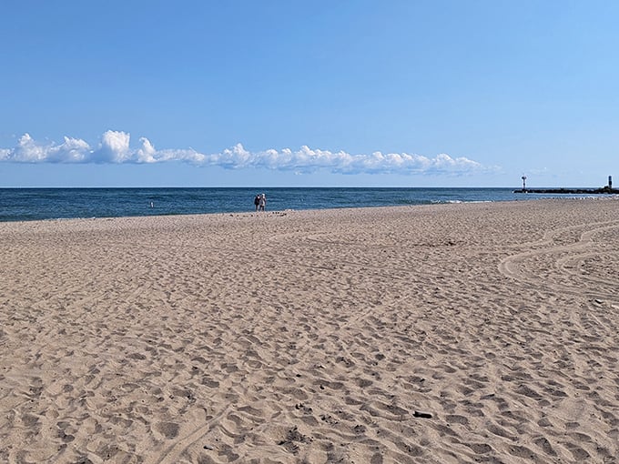 Golden sands stretch toward Lake Erie's horizon, where water meets sky in that perfect vacation tableau you've been searching for all along.