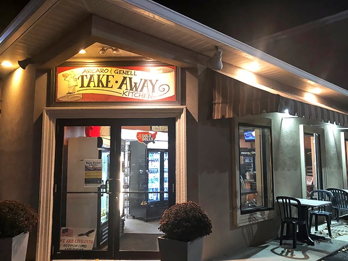 The glowing "TAKE-AWAY KITCHEN" sign at Arcaro and Genell beckons like a lighthouse for hungry travelers in Old Forge's pizza paradise.