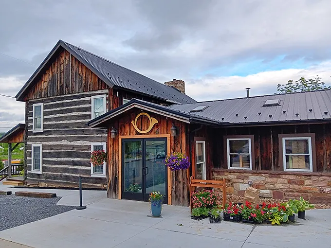 This weathered log cabin exterior whispers promises of comfort food adventures waiting just beyond those rustic doors.