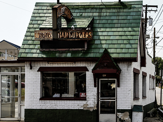 The iconic green-shingled roof and weathered "DONUTS HAMBURGERS" sign announce this Laurel institution without fanfare—architectural honesty at its most delicious.