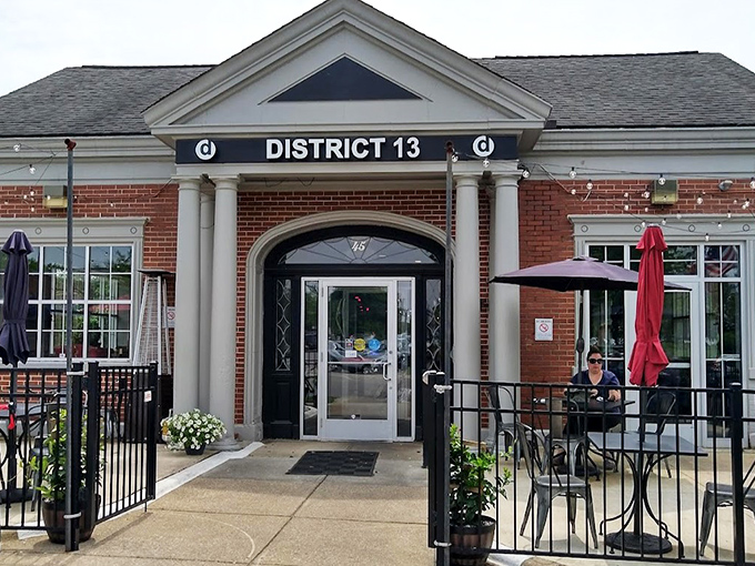 The architectural equivalent of a firm handshake – District 13's brick exterior with white columns promises small-town charm with big-city flavors waiting inside.