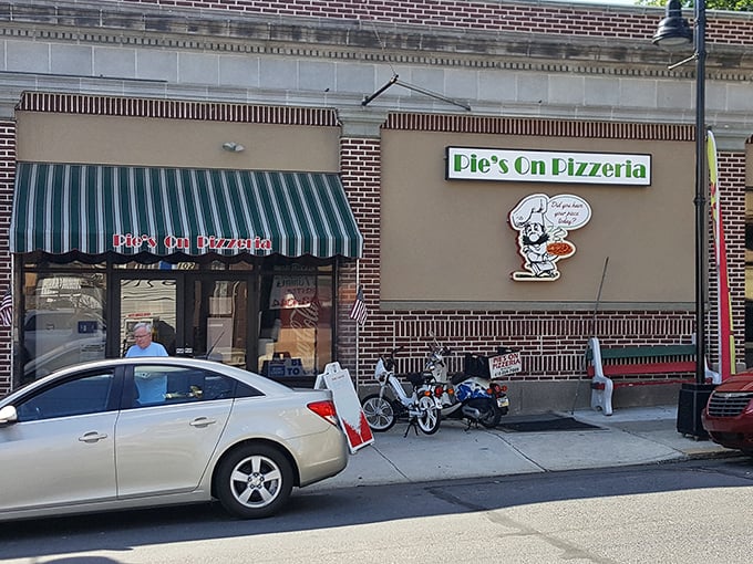 The green and white awning beckons like an old friend saying, "Hey, come get some pizza already!" Classic small-town charm with big pizza energy.