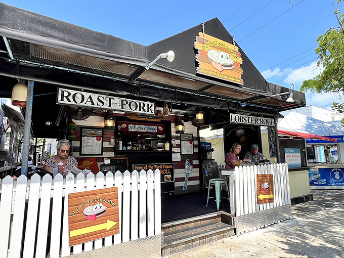 The white picket fence isn't keeping secrets in—that cartoon clam with googly eyes is practically winking at passersby, promising seafood magic within.