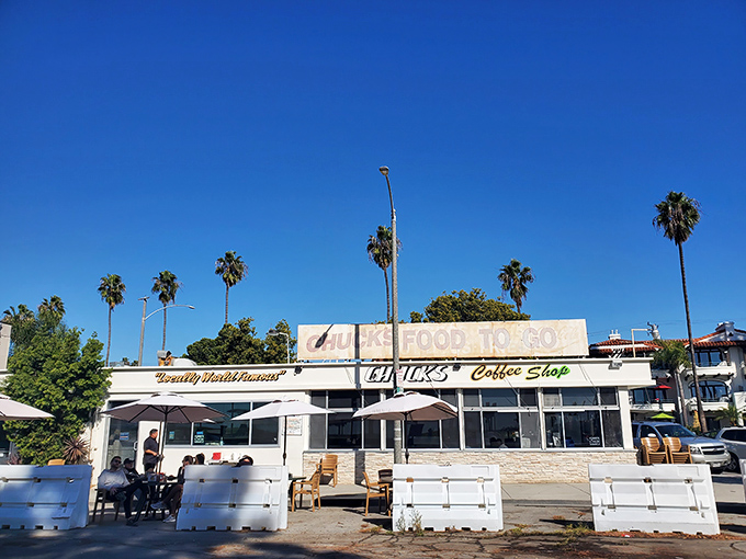 Palm trees and blue skies frame Chuck's Coffee Shop, where the "FOOD TO GO" sign has been beckoning hungry Long Beach locals for generations.