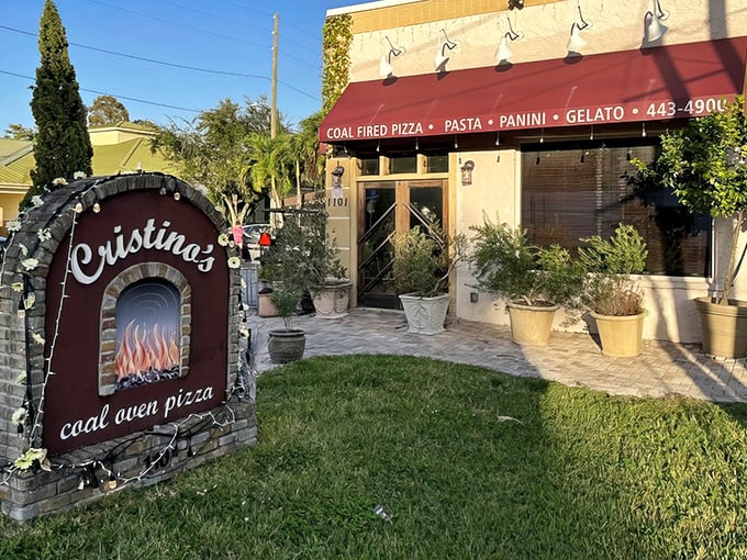 The entrance to pizza paradise! Cristino's charming exterior with its distinctive stone sign promises authentic Italian flavors that await just steps from Gulf-to-Bay Boulevard.