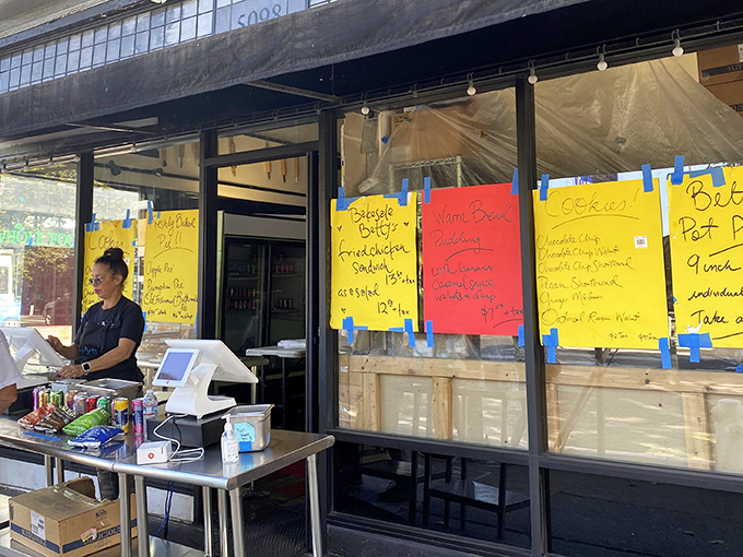 The unassuming storefront of Bakesale Betty, where handwritten menu signs taped to windows tell you everything you need to know: greatness awaits inside.