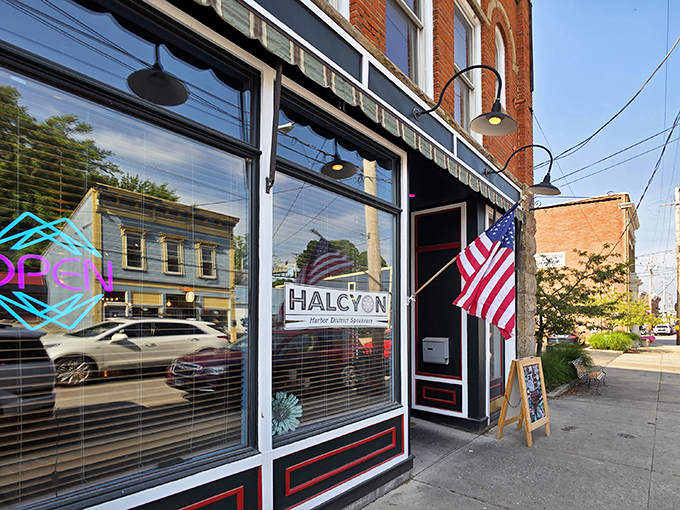 The historic brick façade of Harbor Halcyon welcomes visitors with classic charm and an American flag, promising culinary adventures in Ashtabula Harbor.