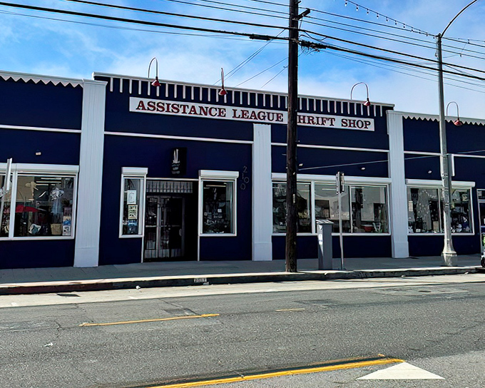 The navy blue façade of Assistance League Thrift Shop stands proudly on the street, like a treasure chest waiting to be opened by curious bargain hunters.