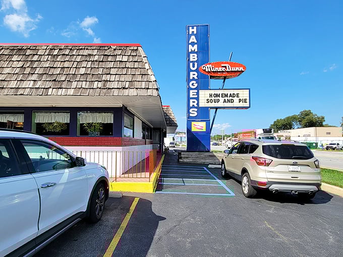 That iconic A-frame roof and vintage neon sign aren't just restaurant architecture—they're a time portal to when burgers were simple and simply perfect.