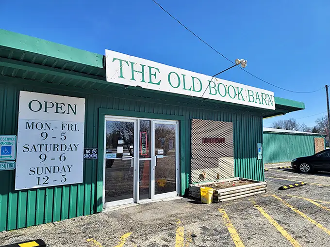 The green exterior of The Old Book Barn stands like a literary oasis in Forsyth, proudly announcing its treasures with a no-nonsense sign and welcoming entrance.