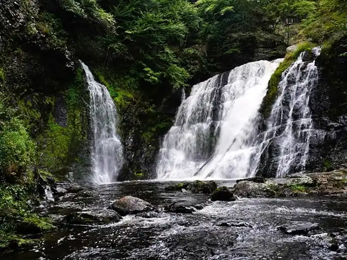 Nature's three-tiered masterpiece puts on a spectacular show, with rushing water carving through ancient rock formations in Pennsylvania's hidden gem.