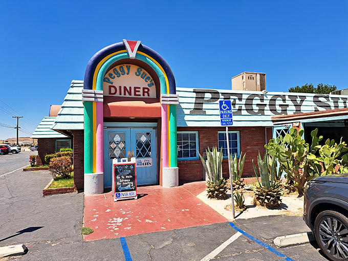 Like a rainbow-colored mirage in the desert, Peggy Sue's 50's Diner stands proudly against the Mojave sky, promising nostalgic delights to weary travelers.