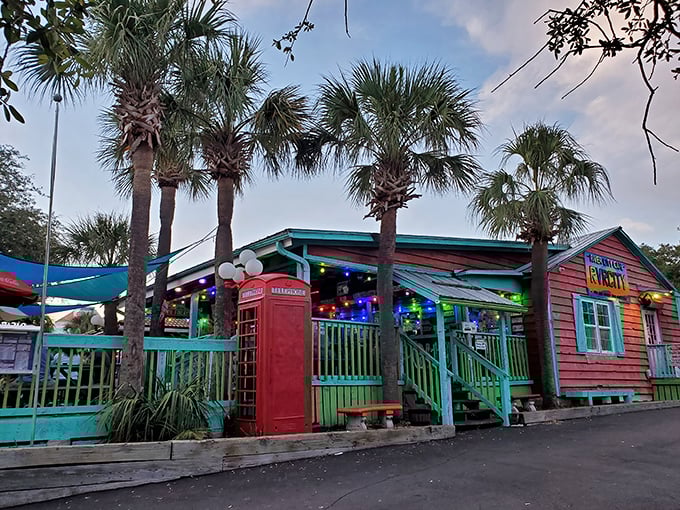 The beach shack of your burger dreams! Vibrant turquoise railings, palm trees, and that iconic red phone booth scream "vacation mode activated."