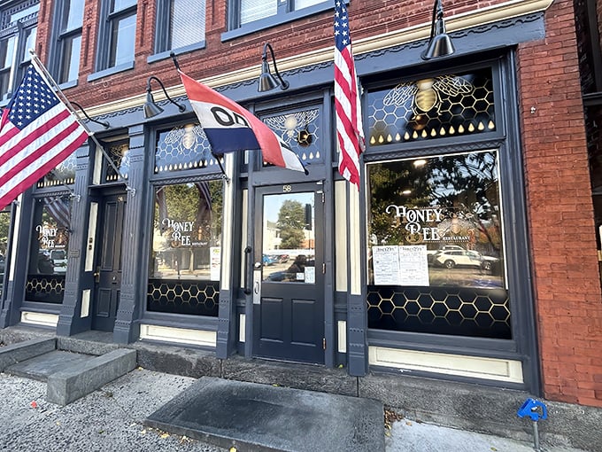 The historic brick façade of Honey Bee Restaurant stands proudly in Gettysburg, its honeycomb-patterned windows and American flags promising both comfort and patriotism inside.