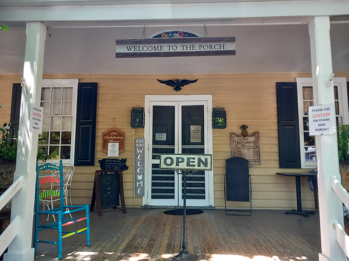 The porch says "Welcome" and means it. That bright blue rocking chair isn't just furniture—it's an invitation to slow down and savor what's coming. 