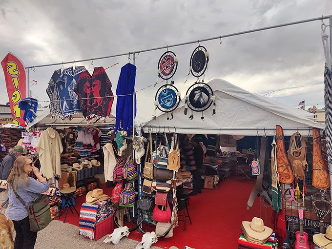 White tents stretching toward the horizon, colorful flags snapping in the desert breeze—Tyson Wells isn't just a market, it's a pop-up retail city.
