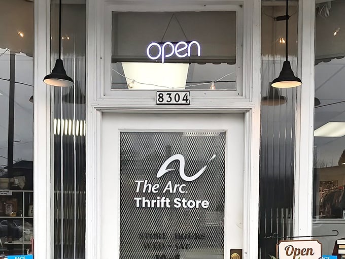 The welcoming storefront of The Arc Thrift Store beckons with its glowing neon sign—like a lighthouse guiding bargain hunters to treasure-filled shores.
