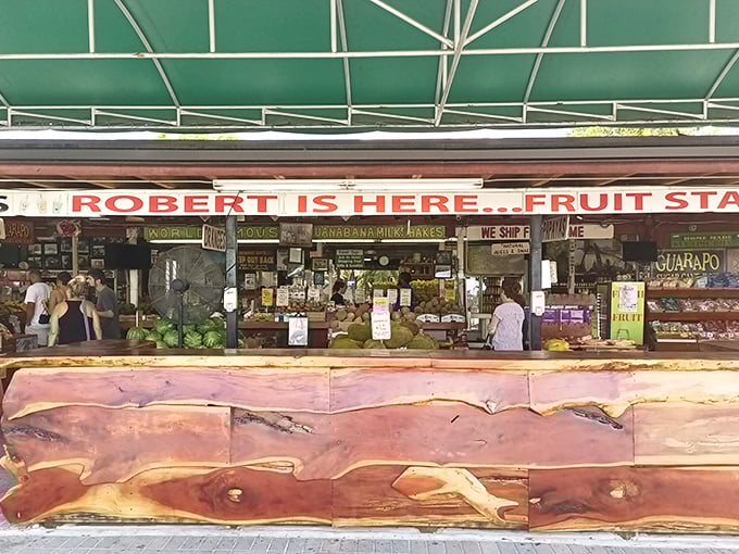 The wooden counter stretches like a rustic welcome mat, with "ROBERT IS HERE" proudly announcing itself to fruit pilgrims seeking tropical treasures.