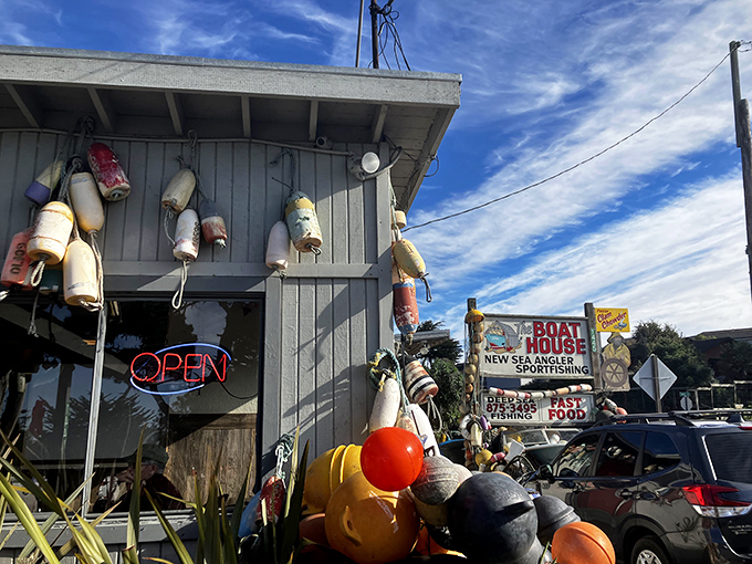 Colorful buoys dangle like maritime Christmas ornaments from this weathered gray shack. The neon "OPEN" sign promises seafood treasures await inside.
