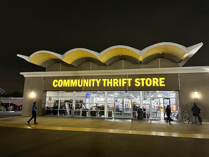 The iconic yellow sign glows like a beacon for bargain hunters, promising treasures within those distinctive wavy-roofed walls.
