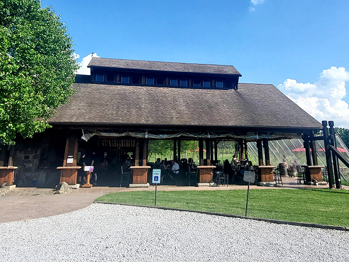 The rustic barn exterior of Sarah's Vineyard welcomes visitors with its weathered wood charm and inviting outdoor seating—Napa Valley spirit with heartland hospitality.
