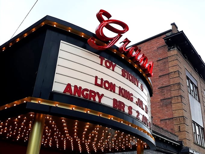 The iconic red neon "Grand" sign glows against the brick facade, announcing today's features with vintage flair that no digital display could match.