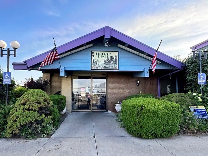 Liberty Diner's patriotic blue-and-purple exterior stands like a delicious fortress of breakfast possibilities, American flags waving "come and get it!"