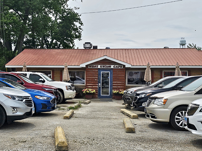 The rustic log cabin exterior of West Union Café promises homestyle cooking that your grandmother would approve of—if your grandmother was secretly a culinary genius.