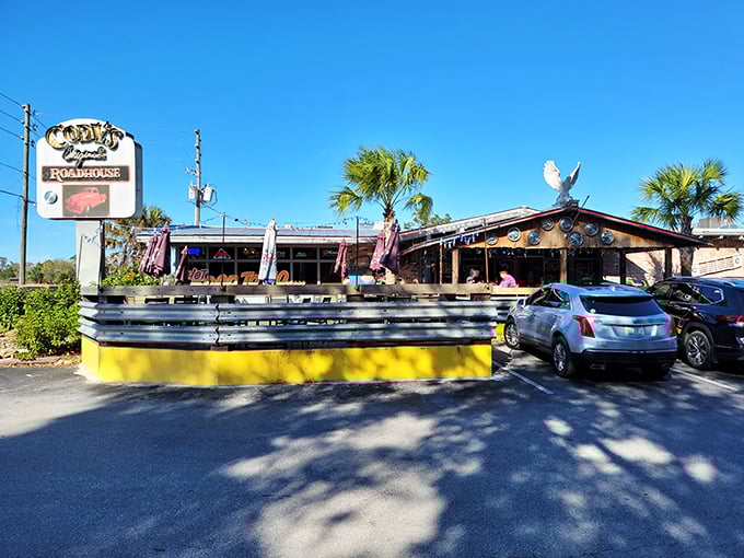 The classic roadhouse exterior beckons with its vintage sign and sunny yellow patio wall—Florida's answer to "come as you are, leave happier than you arrived."