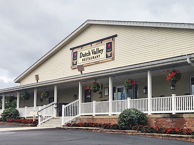 The welcoming facade of Dutch Valley Restaurant stands like a beacon of comfort food in Sugarcreek, complete with rocking-chair-ready porch and hanging flower baskets.