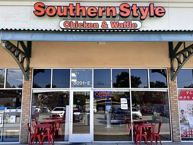 The bright red signage of Southern Style Chicken & Waffle beckons like a lighthouse to hungry souls navigating the sea of strip mall sameness.