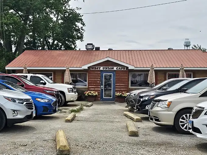 The rustic log cabin exterior of West Union Café promises homestyle cooking that your grandmother would approve of—if your grandmother was secretly a culinary genius.