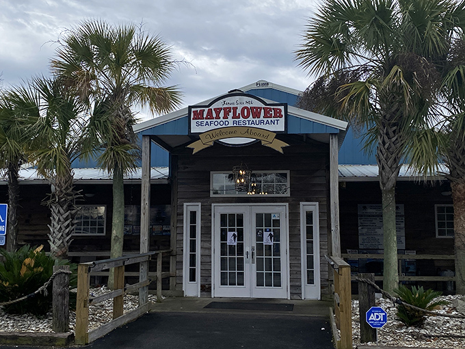 Palms standing guard at this maritime haven, the Mayflower's blue-trimmed facade promises seafood treasures within, no passport required.