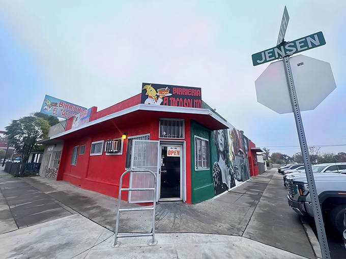 The unassuming corner building in red and green announces itself with no pretense—just the quiet confidence of a place that knows its birria speaks volumes.