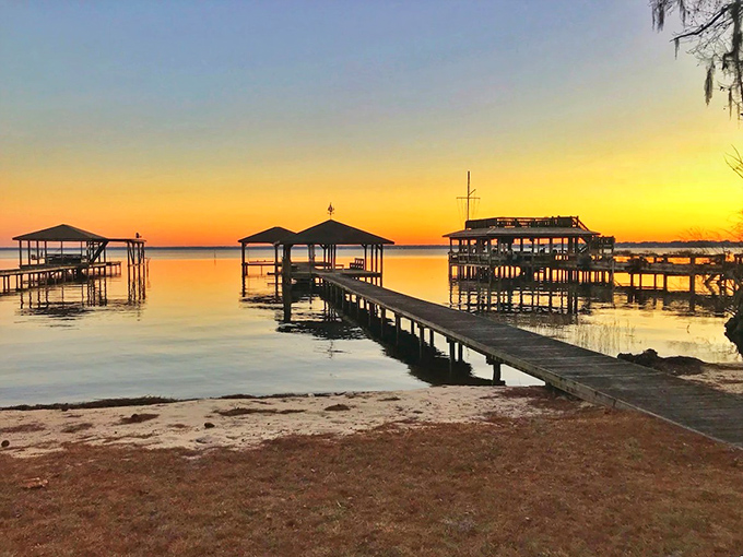 Sunset transforms Lake Waccamaw's wooden piers into silhouettes against a golden sky. Nature's own light show outperforms any Broadway production.