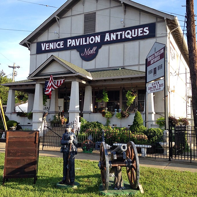 The stately white facade of Venice Pavilion Antiques welcomes treasure hunters with its Civil War-era cannon display and inviting front porch.