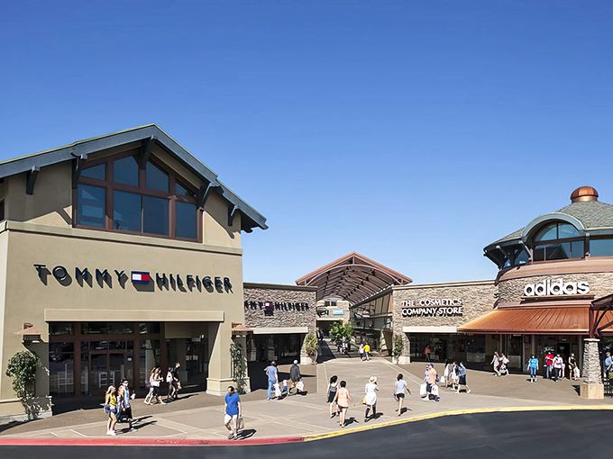 The Northwest-inspired architecture of Woodburn Premium Outlets welcomes shoppers with its distinctive peaked roofs and stone facades—retail therapy with a touch of mountain lodge aesthetic.
