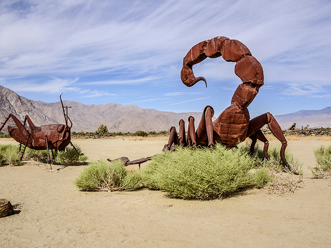 Desert showdown! A massive metal scorpion faces off against an ant in this surreal landscape where prehistoric creatures rule the sand.
