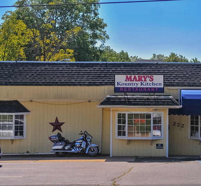 The unassuming yellow exterior of Mary's Kountry Kitchen, complete with rustic star and motorcycle, promises authentic comfort without pretension.