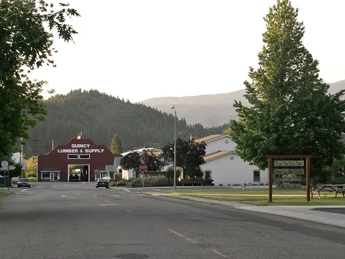 Welcome to Quincy, where the iconic lumber supply store stands as a friendly sentinel against a backdrop of mountains that seem to whisper, "Slow down, you're home now."
