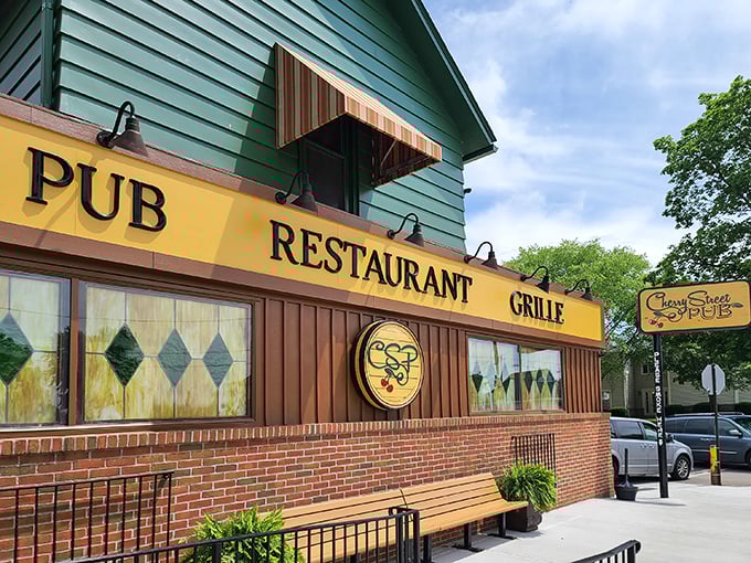 The green exterior of Cherry Street Pub welcomes you with its bright yellow signage—like that friendly neighbor whose house always smells amazing at dinnertime.