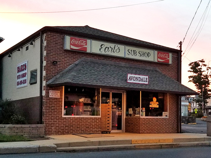The brick façade of Earl's Sub Shop stands as a timeless monument to sandwich perfection, beckoning hungry travelers with its classic Coca-Cola signage and small-town charm.