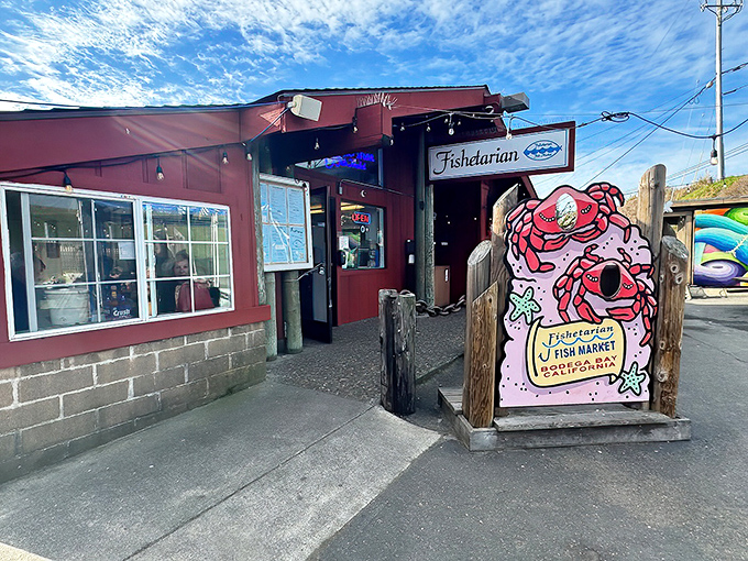 The unassuming red exterior of Fishetarian Fish Market, where that cheerful crab sign promises seafood treasures that outshine many white-tablecloth establishments along the coast.
