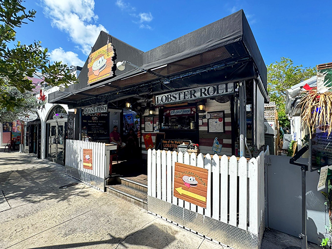 The white picket fence isn't keeping anyone out—it's practically herding seafood lovers into this Key West treasure on bustling Duval Street.