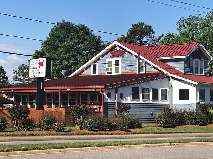 The blue-gray clapboard exterior with its signature red roof stands like a seafood lighthouse, beckoning hungry travelers with promises of crab-filled dreams.