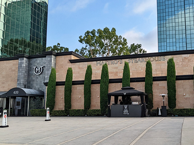 The stone façade and perfectly manicured cypress trees aren't just for show—they're your first clue that dinner tonight will be several notches above a drive-thru experience.