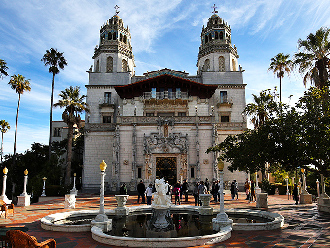 The twin bell towers of Hearst Castle reach skyward like Mediterranean dreams transplanted to California soil, where palm trees and Spanish architecture create an otherworldly entrance.